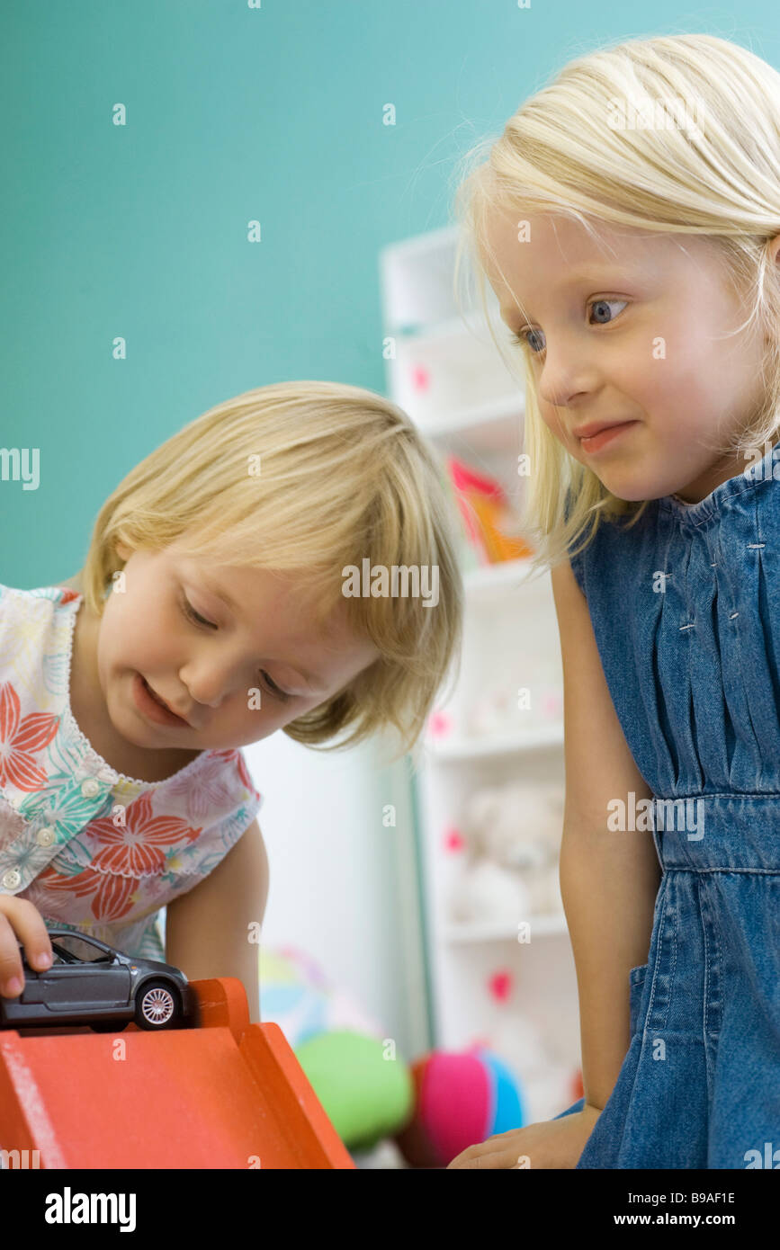Little girls playing with toy car Stock Photo - Alamy
