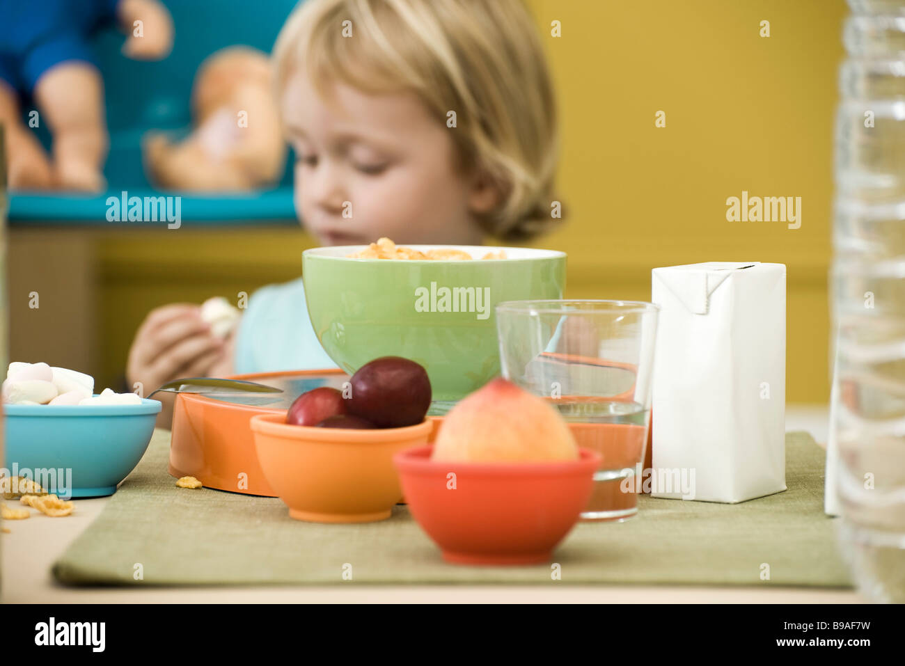 Little girl eating snack at messy table Stock Photo - Alamy