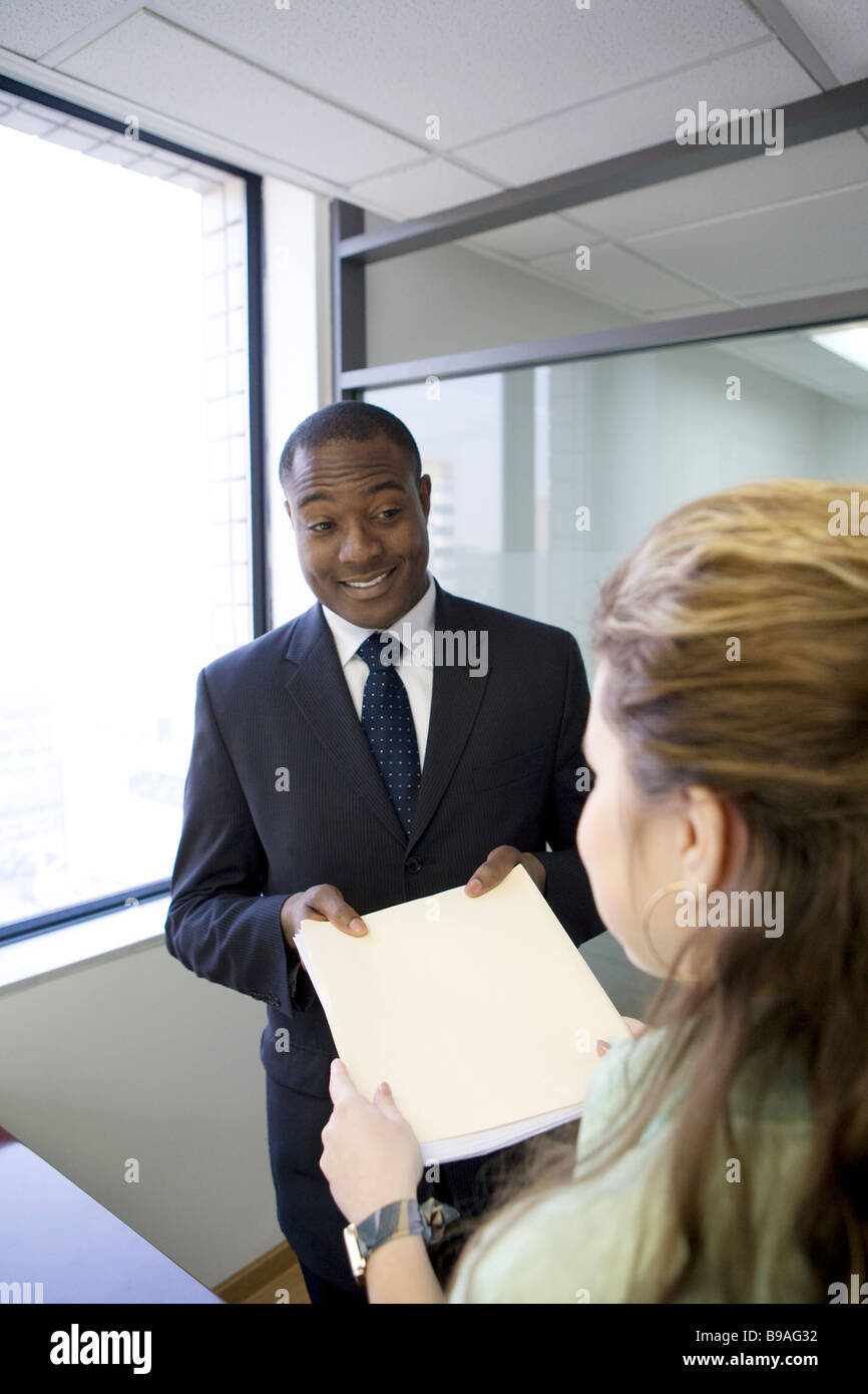 Businessman taking file from co worker Stock Photo - Alamy