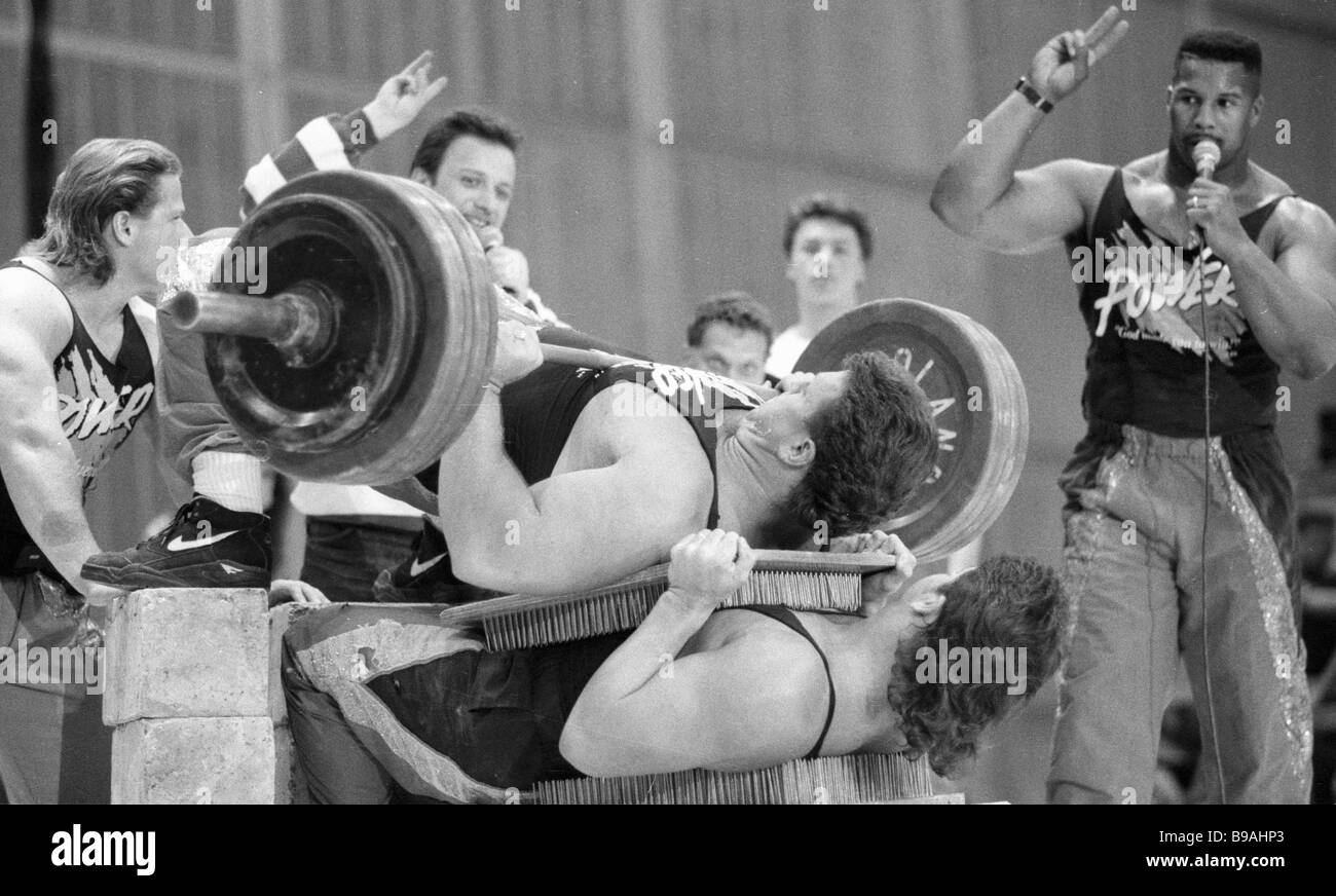 Power group stunt weight lifting on a bed of nails Stock Photo - Alamy