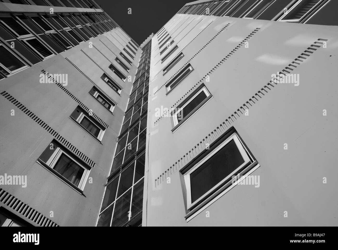 A 1960`s block of flats viewed upwards in monotone with a corner of sky ...