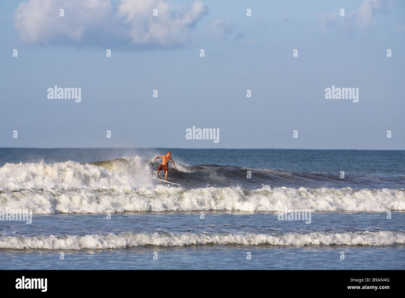 Surfer surfing the break at Playa Dominical in Puntarenas, Costa Rica ...