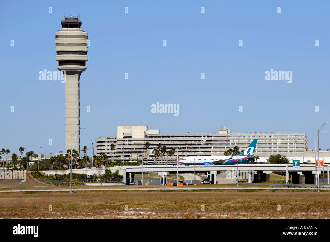 Airplane jet taxis on runway Control Tower at Orlando International ...