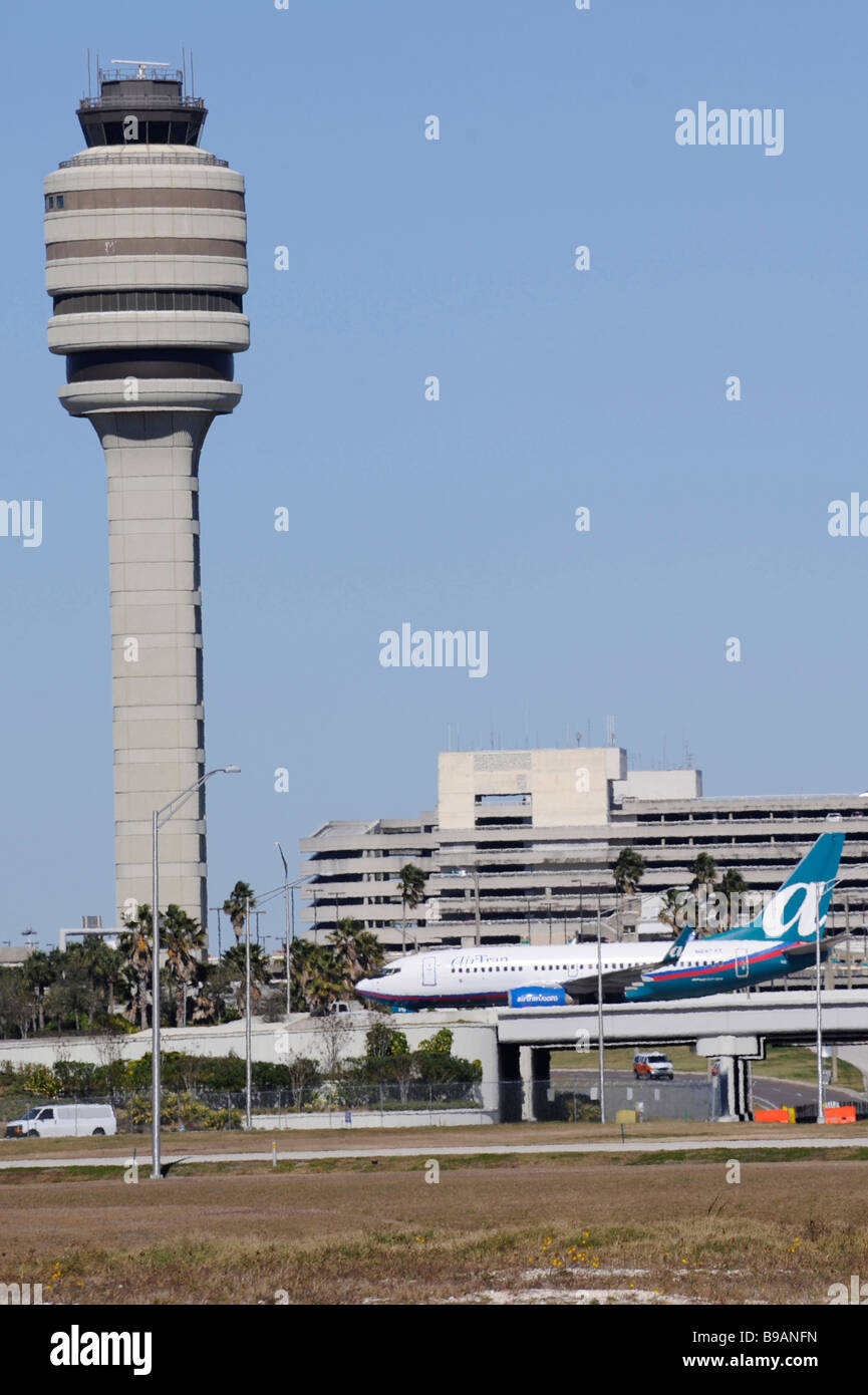 Airplane jet taxis on runway Control Tower at Orlando International ...