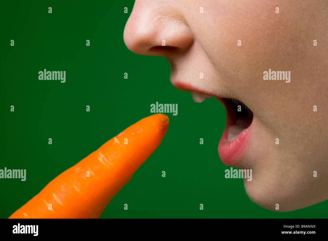 Studio portrait woman eating carrot hi-res stock photography and images ...