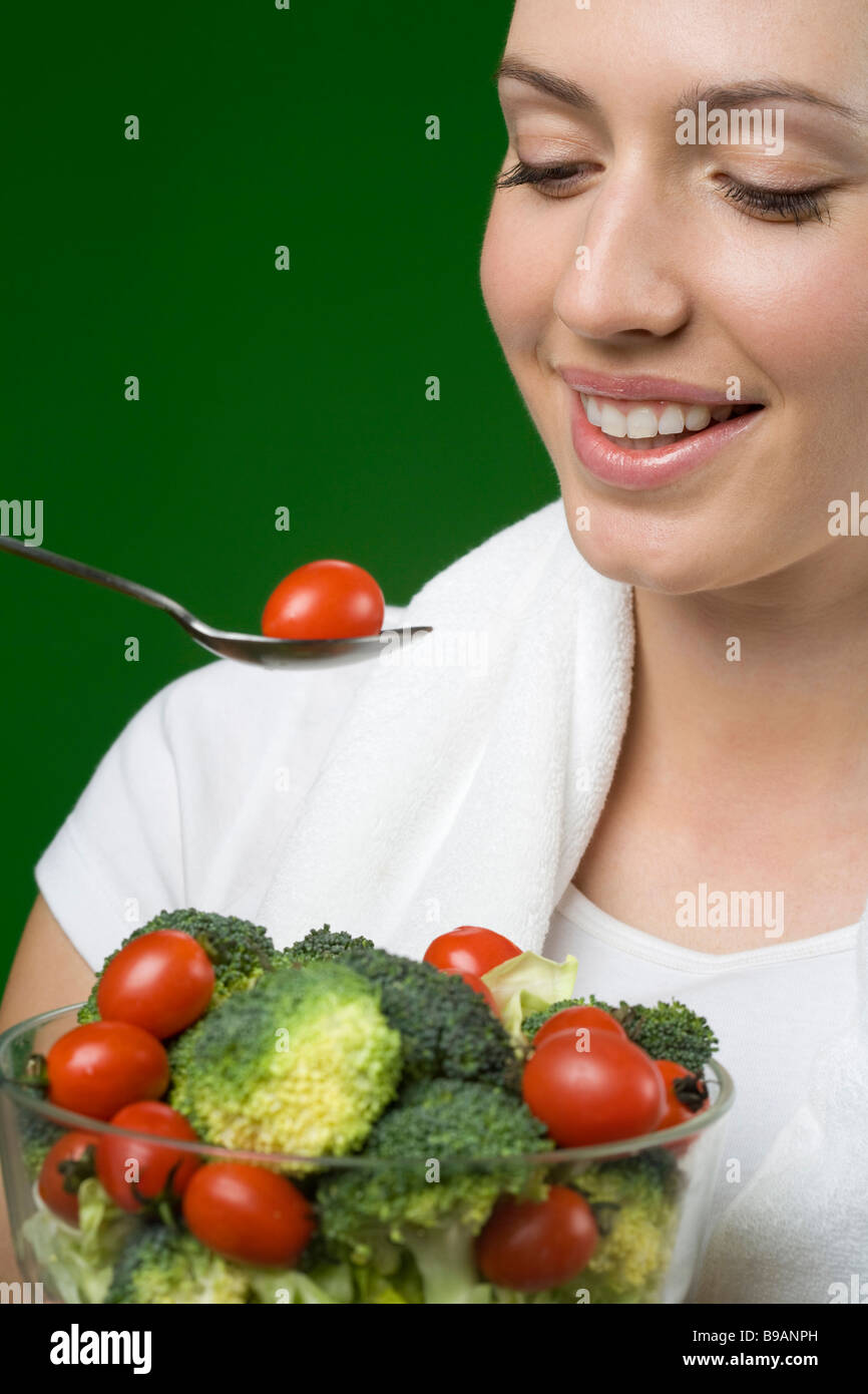 Woman eating tomato and broccoli salad Stock Photo - Alamy