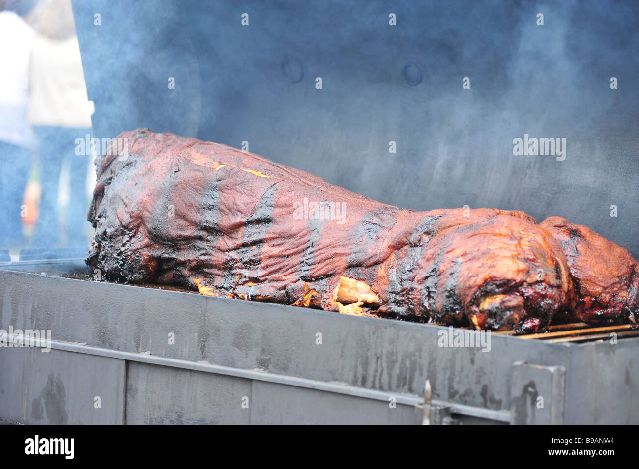 Pig roasting on an open grill Stock Photo - Alamy