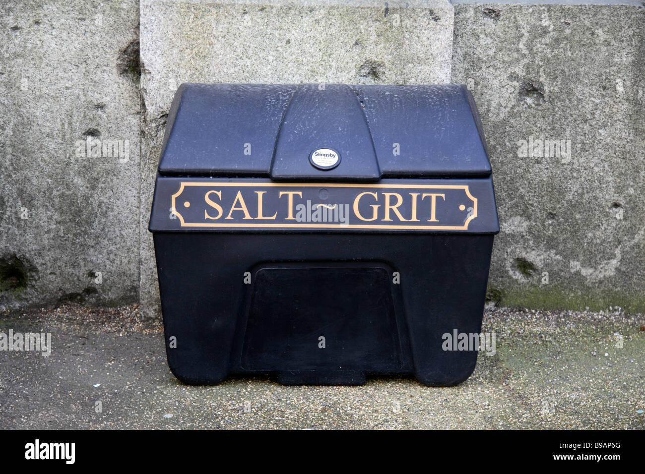 A salt grit container beside a pedestrian area near the entrance to the ...