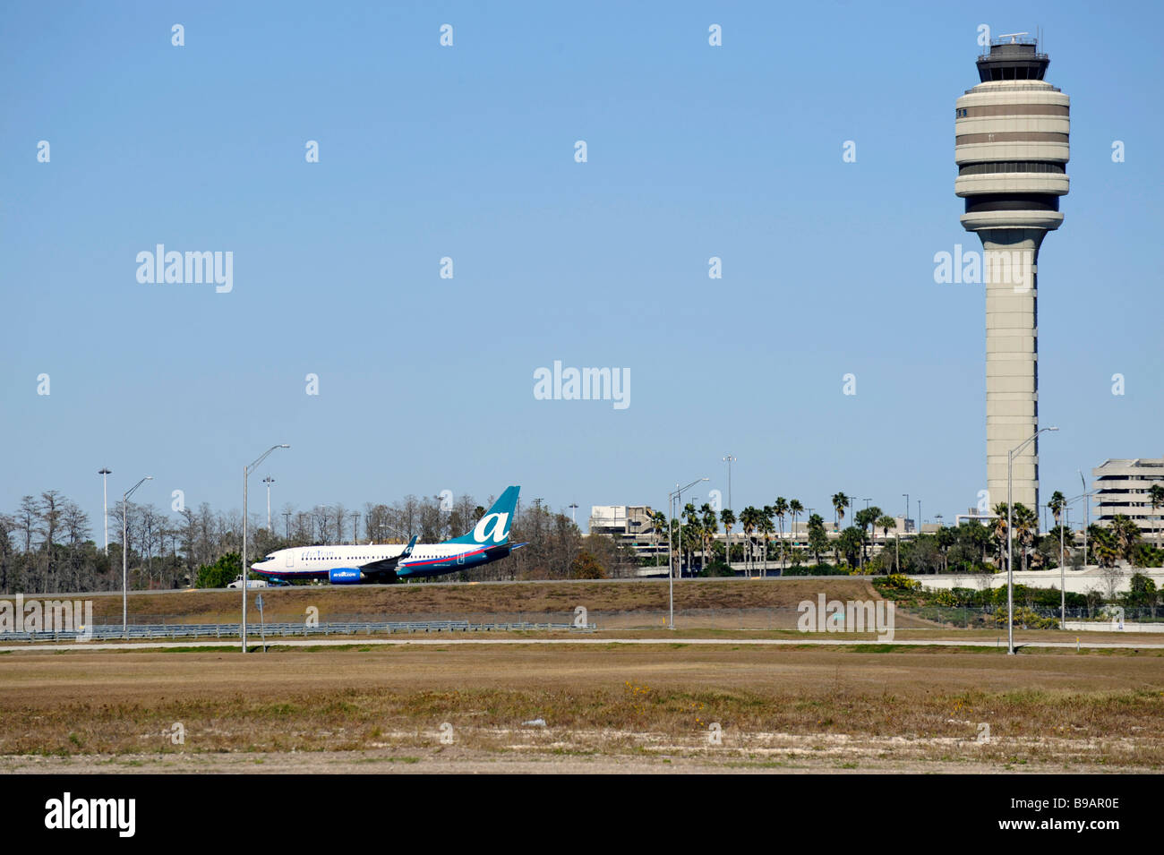 Airplane jet taxis on runway Control Tower at Orlando International ...