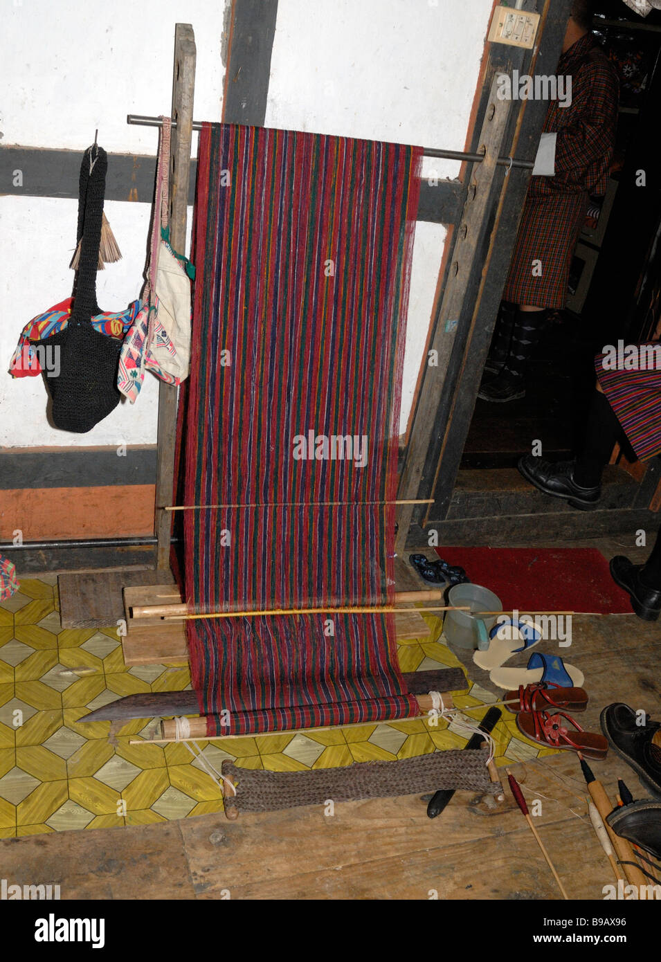 A backstrap loom set up on the verandah of a farm house for weaving a ...
