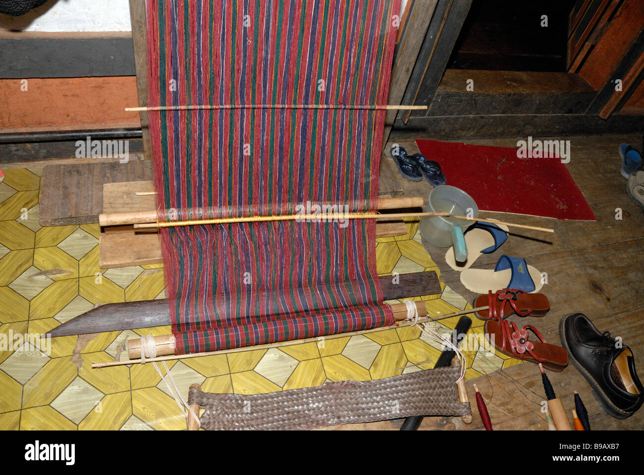 A backstrap loom set up on the verandah of a farm house for weaving a ...