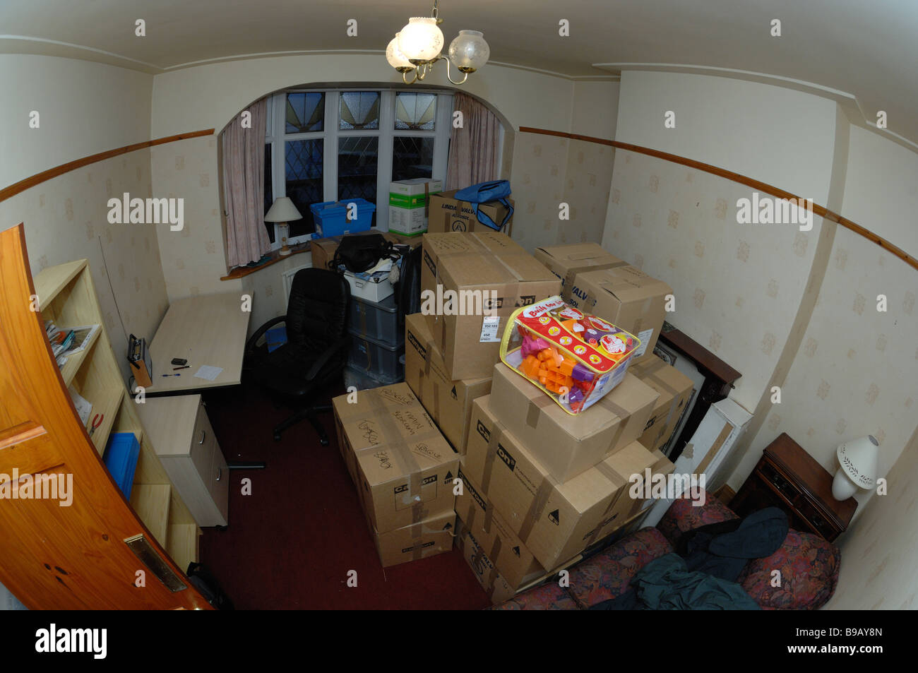 A pile of boxes in the front room of a house ready for moving Stock ...