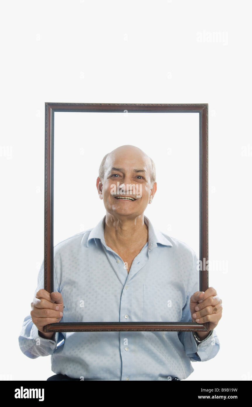 Man holding a picture frame and smiling Stock Photo - Alamy