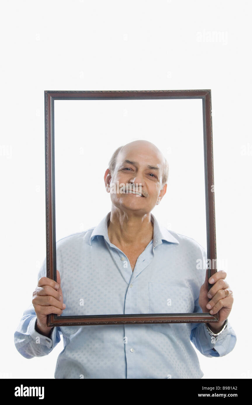 Man holding a picture frame and smiling Stock Photo - Alamy