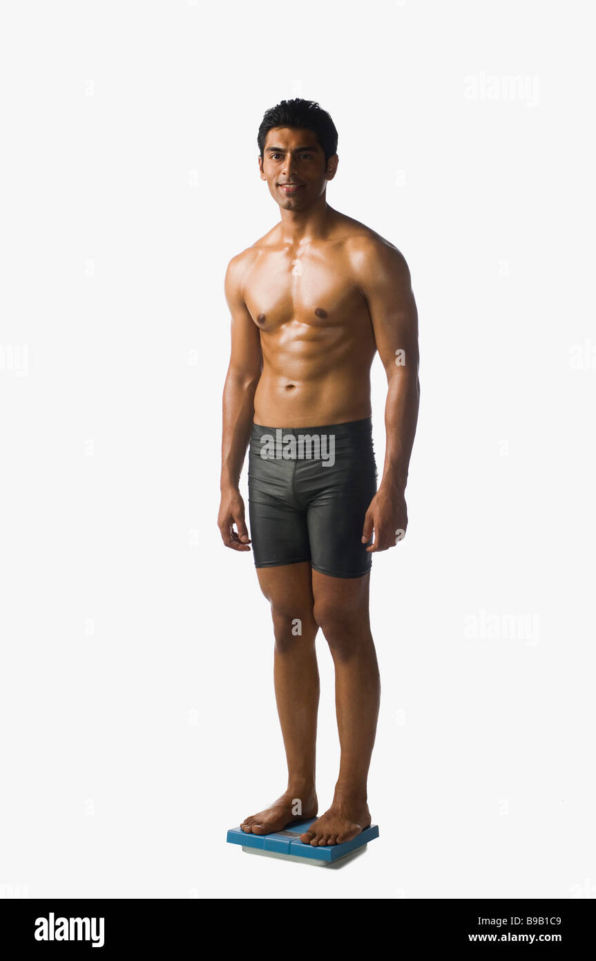Man measuring his weight on a weighing scale Stock Photo - Alamy