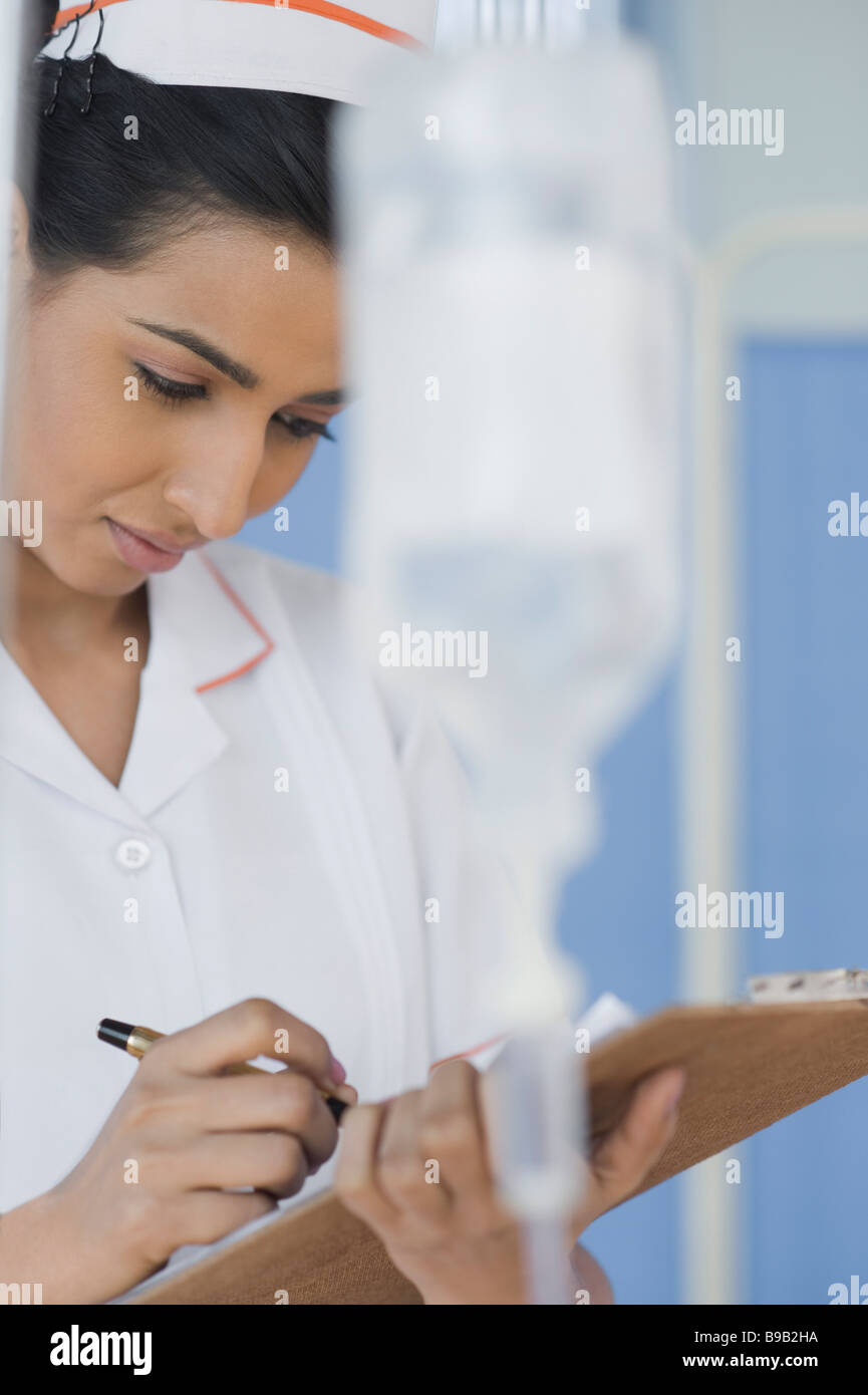 Female nurse writing on a clipboard Stock Photo - Alamy