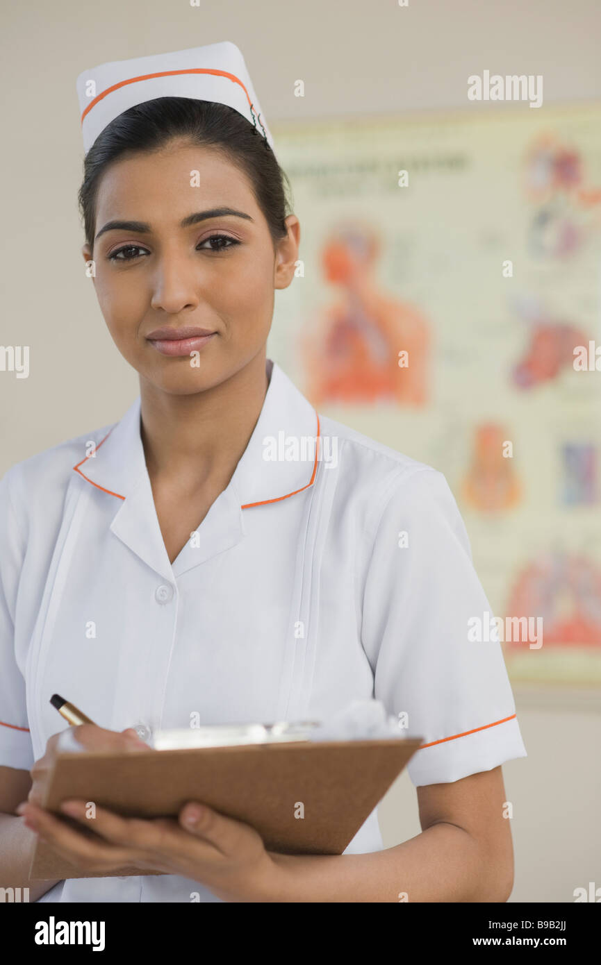 Female nurse writing on a clipboard Stock Photo - Alamy