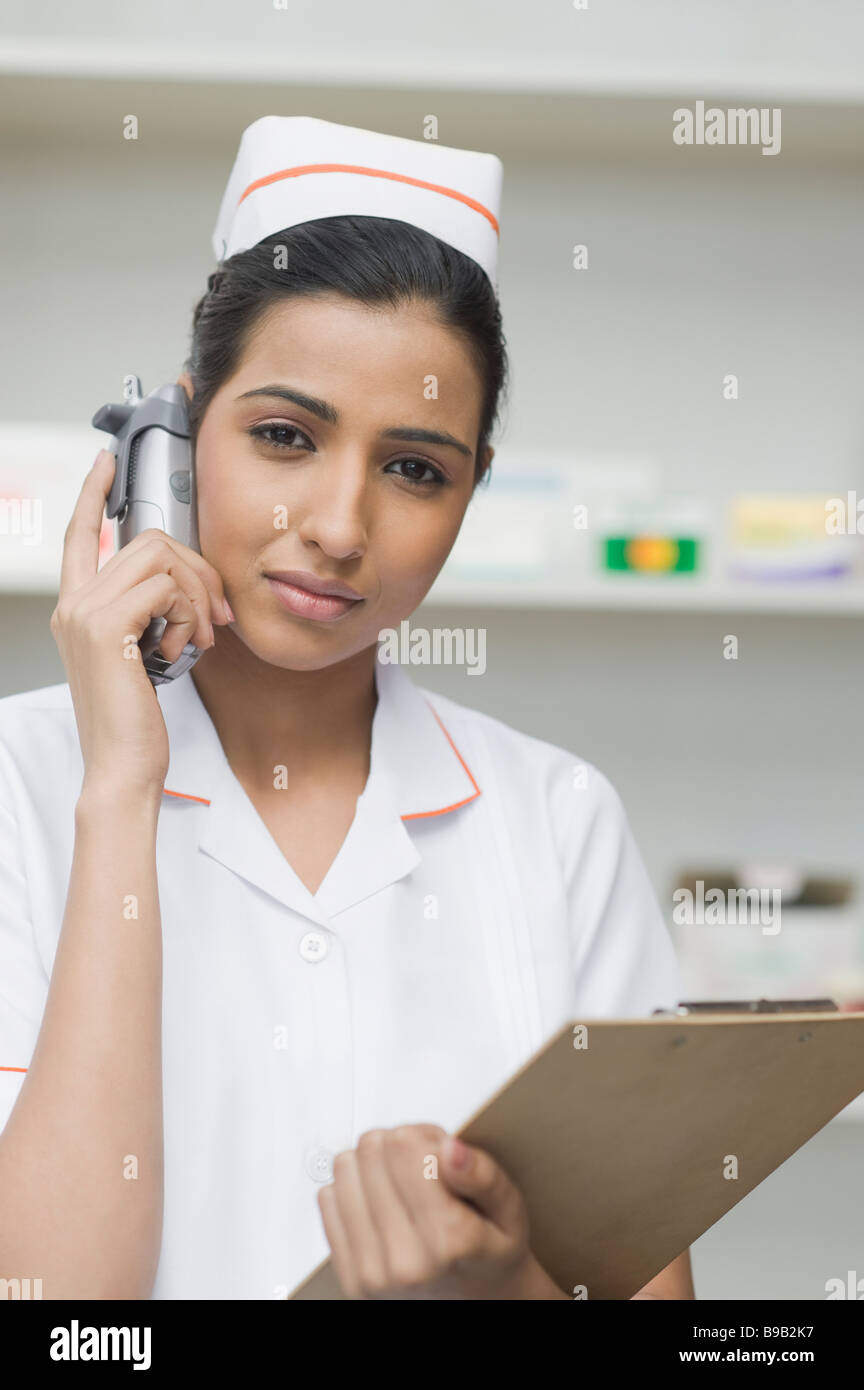 Female nurse talking on a mobile phone Stock Photo - Alamy