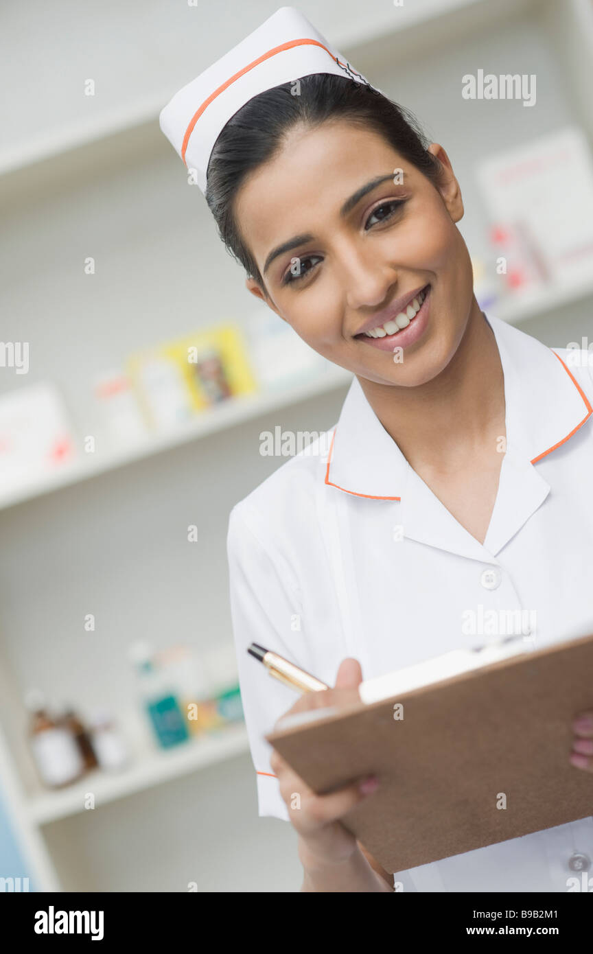 Female nurse writing on a clipboard Stock Photo - Alamy