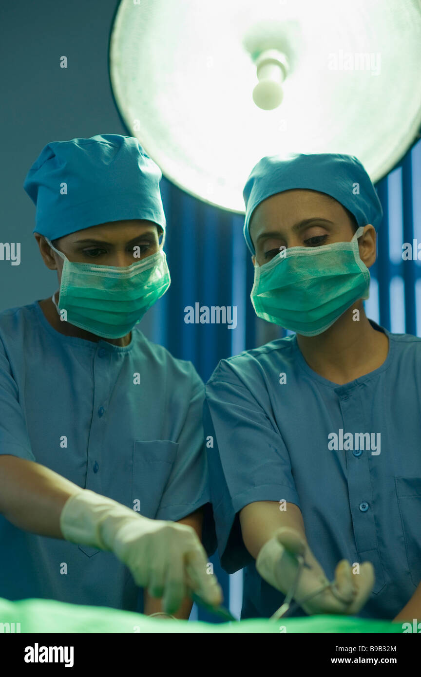 Two female surgeons performing a surgery in an operating room Stock ...