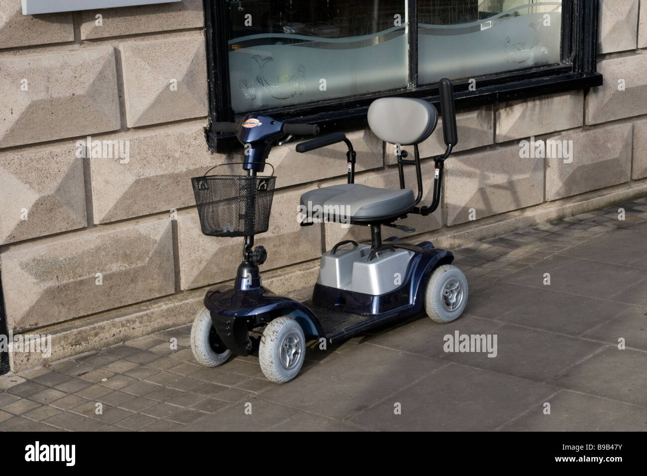 Mobility Scooter parked on pavement Stock Photo - Alamy