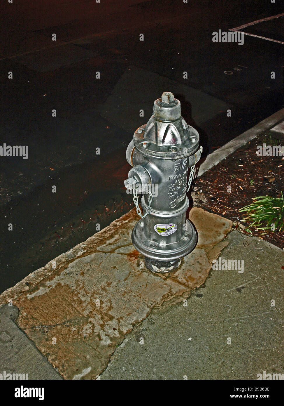 silver fire hydrant on sidewalk and street taken at night bright Stock ...