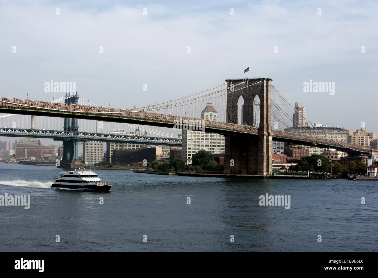 A ferry on the East River going under the Brooklyn Bridge in New York ...