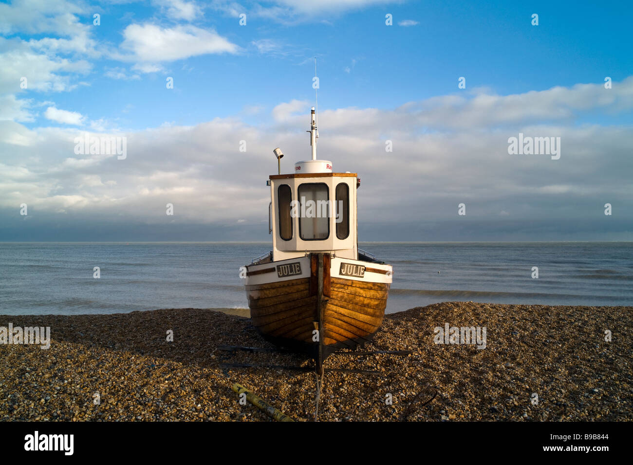 A traditional clinker built fishing boat drawn up on Walmer beach Kent ...