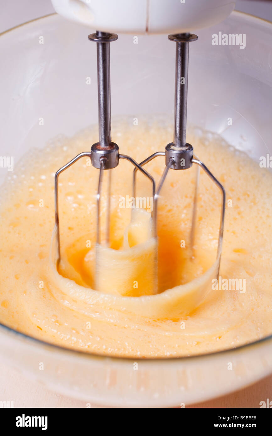 Whisking eggs with cake ingredients with electric mixer Stock Photo - Alamy