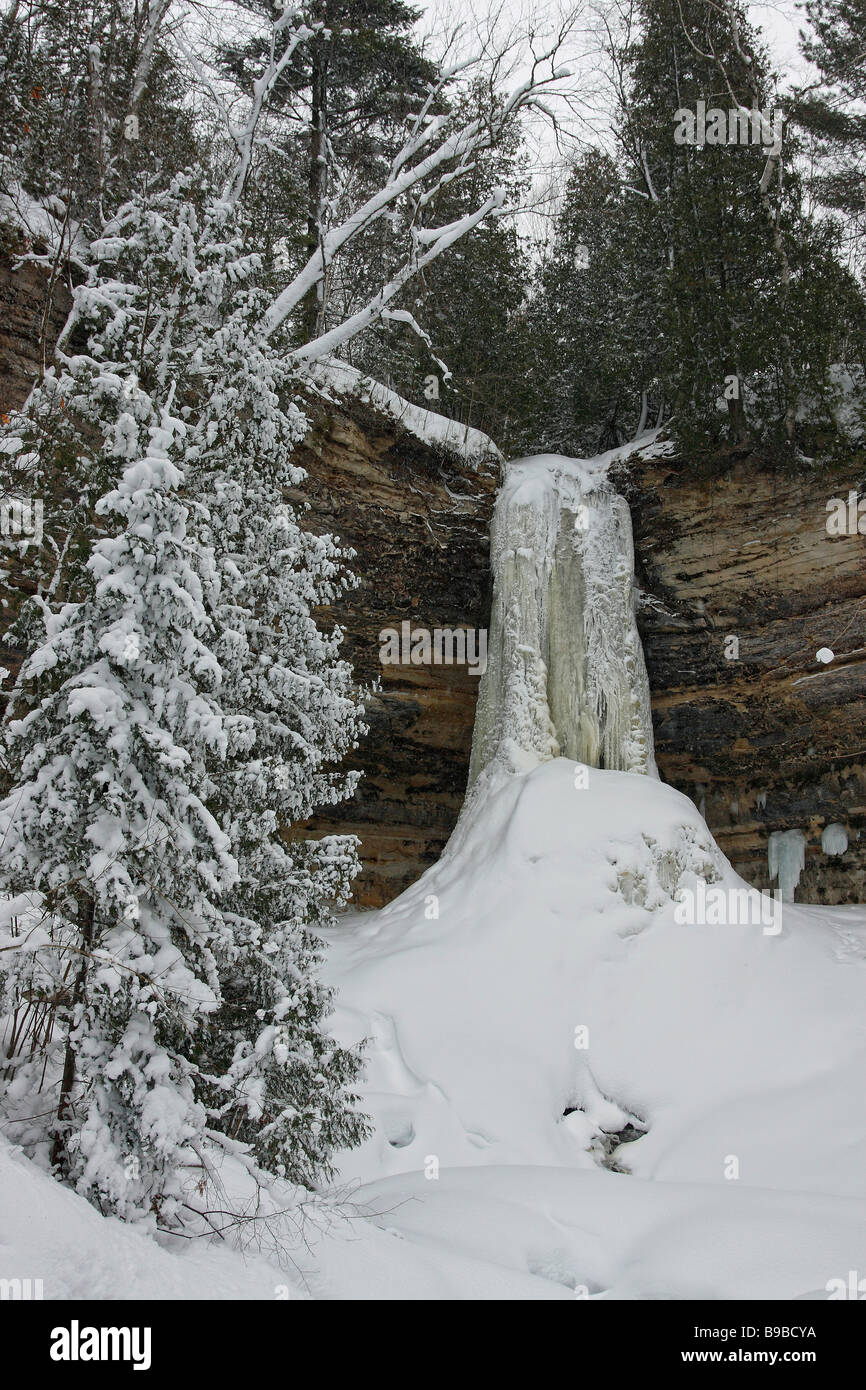 Winter landscape with snowy forest covered trees and frozen waterfall ...