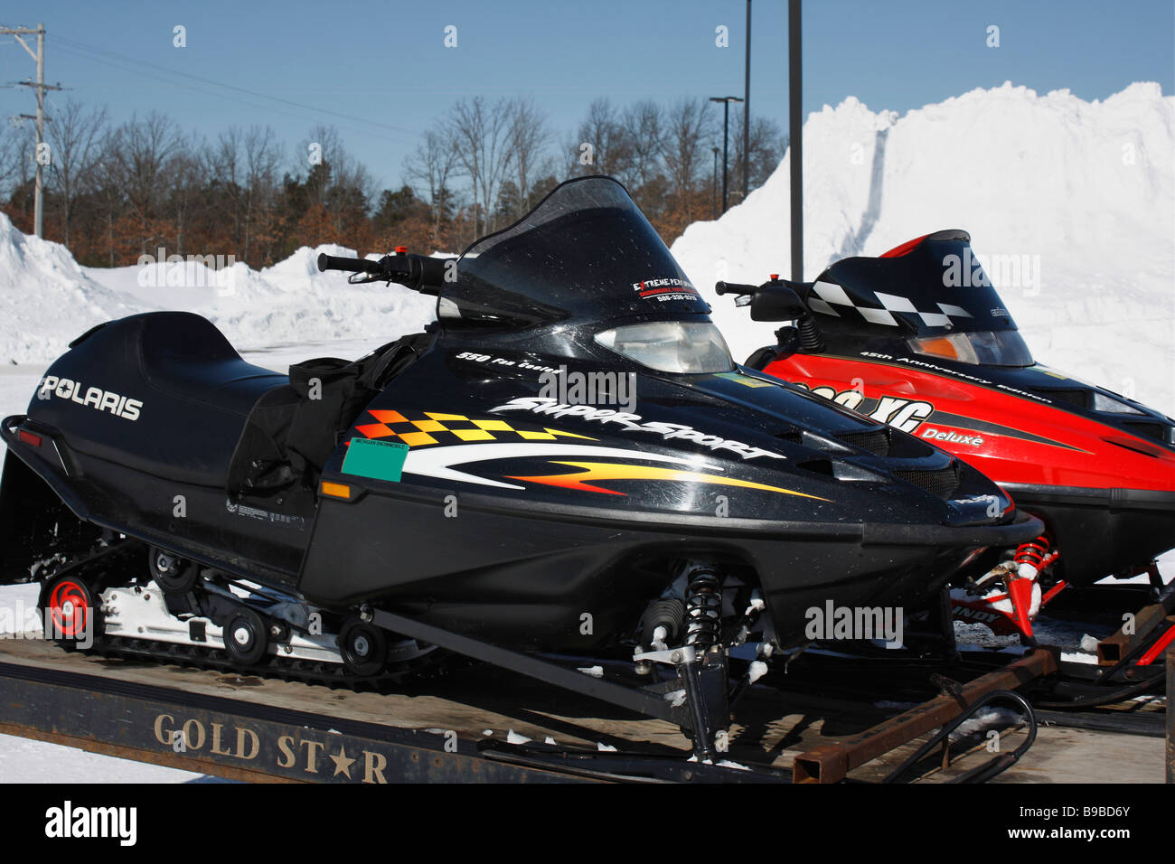 Snowmobile parked on the city street in the snow drifts in a small town ...