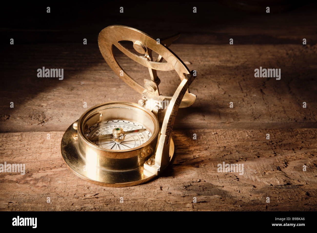 Vintage golden compass lying on an old wooden board Stock Photo - Alamy