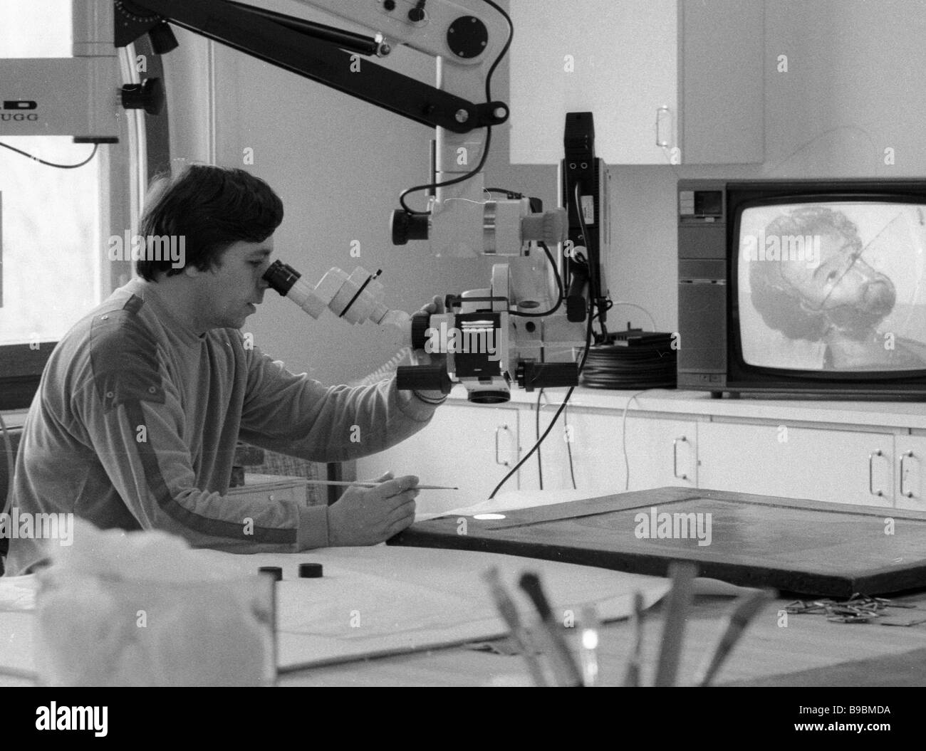 Artist restorer Igor Sklyarenko working with electronic microscope at ...