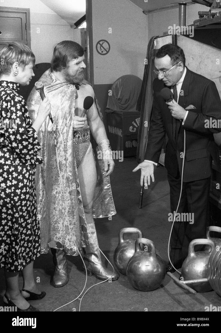 Weight lifting juggler Valentin Dikul centre is giving interview to a ...