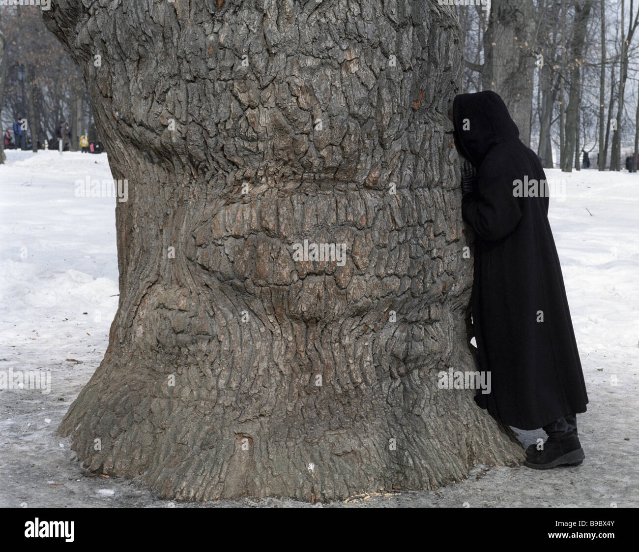 A woman leaning against the tree Stock Photo - Alamy