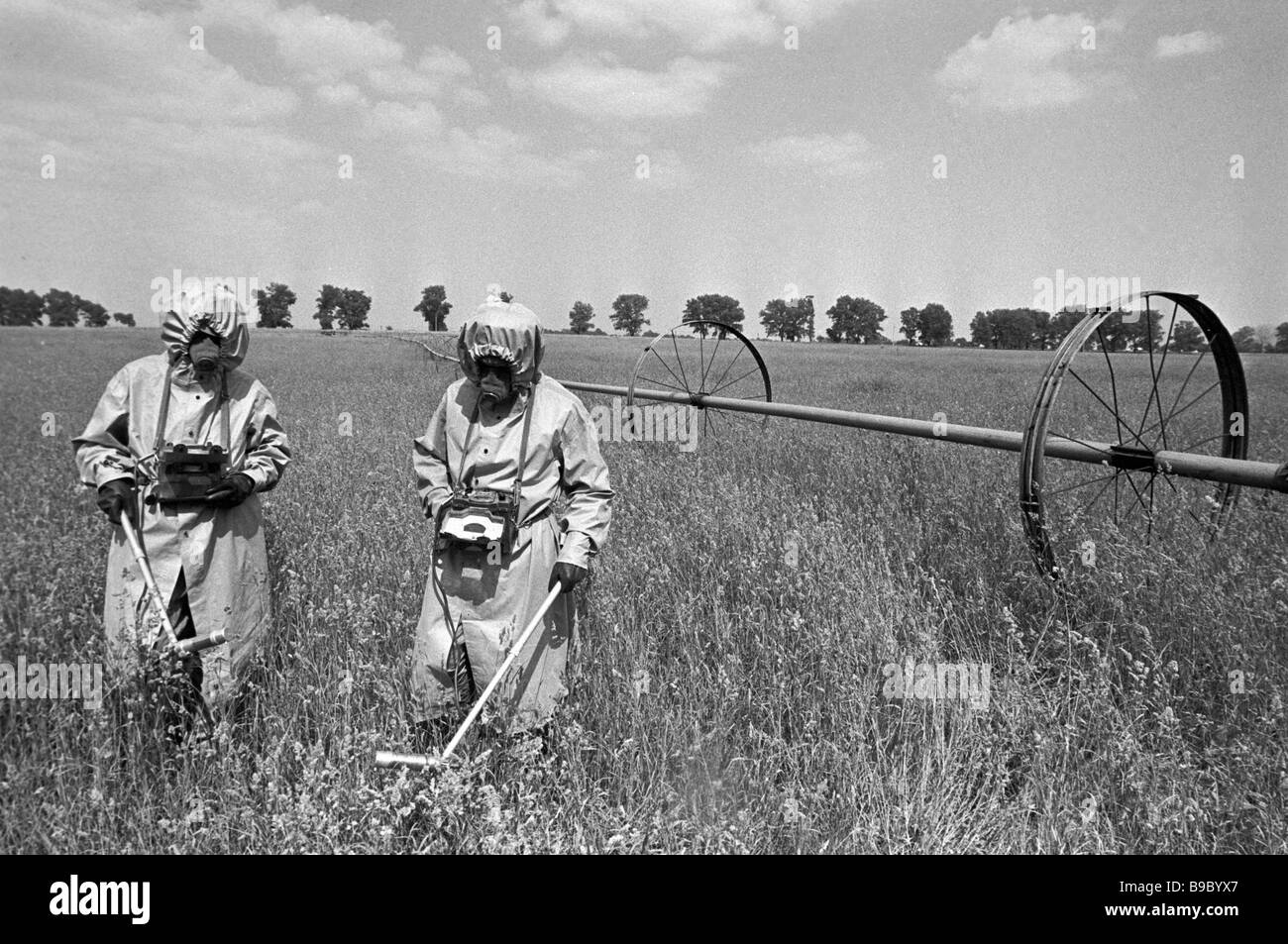 Health physicists in special suits controlling radiation in the fields ...