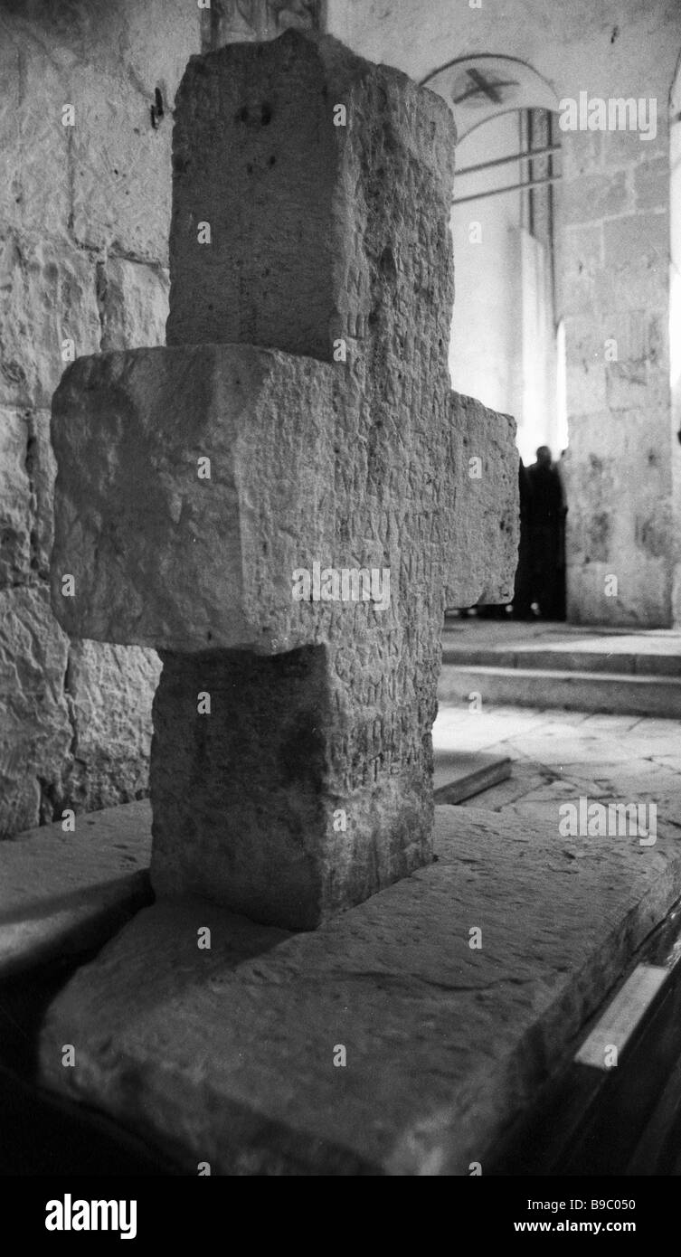 The white stone cross with the In Praise of the Cross engraving a ...