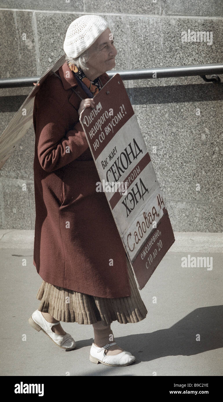 An old woman advertising a second hand garment shop Stock Photo - Alamy