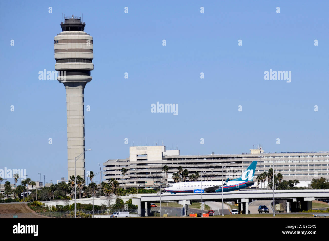 Airplane jet taxis on runway Control Tower at Orlando International ...