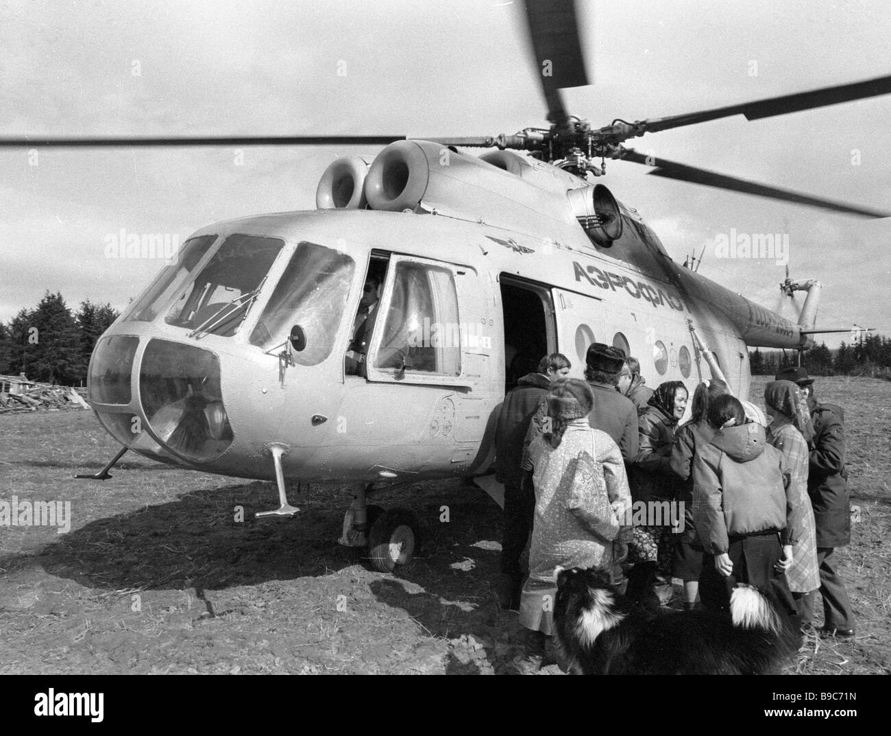 Residents of the taiga village of Atan standing by a helicopter Stock ...