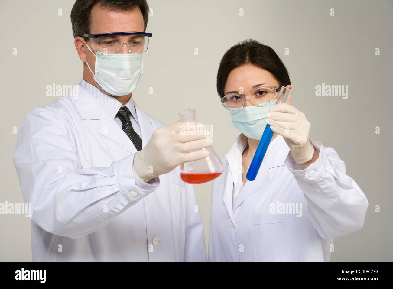 Scientists examining liquids in beakers Stock Photo - Alamy