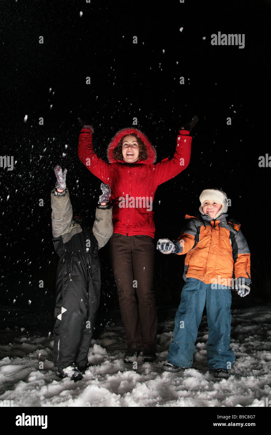 children and mother throw snow in the night 3 Stock Photo - Alamy