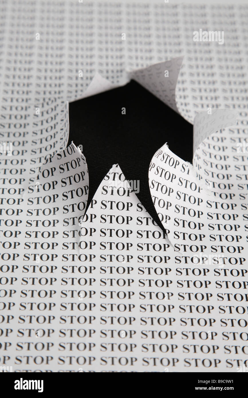 the sheet of paper with printing word stop and the cut hole against the ...