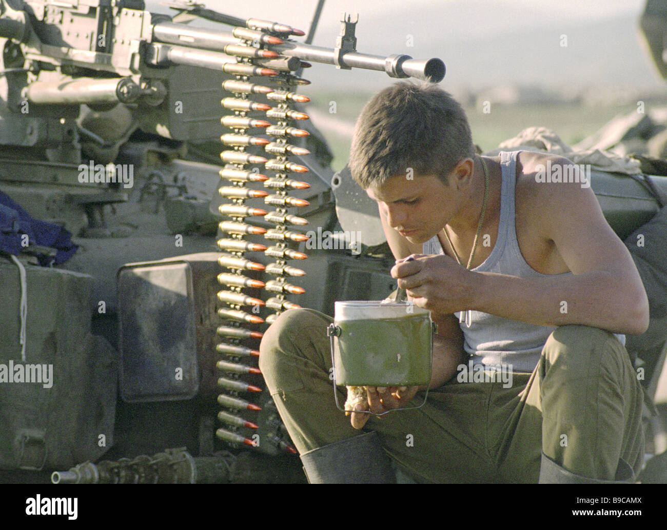 A soldier eating cereal near an armor machinegun Stock Photo - Alamy