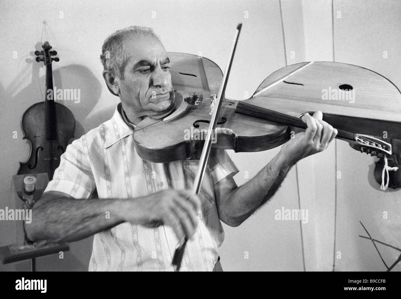 A violinmaker playing an unusual violin Stock Photo - Alamy