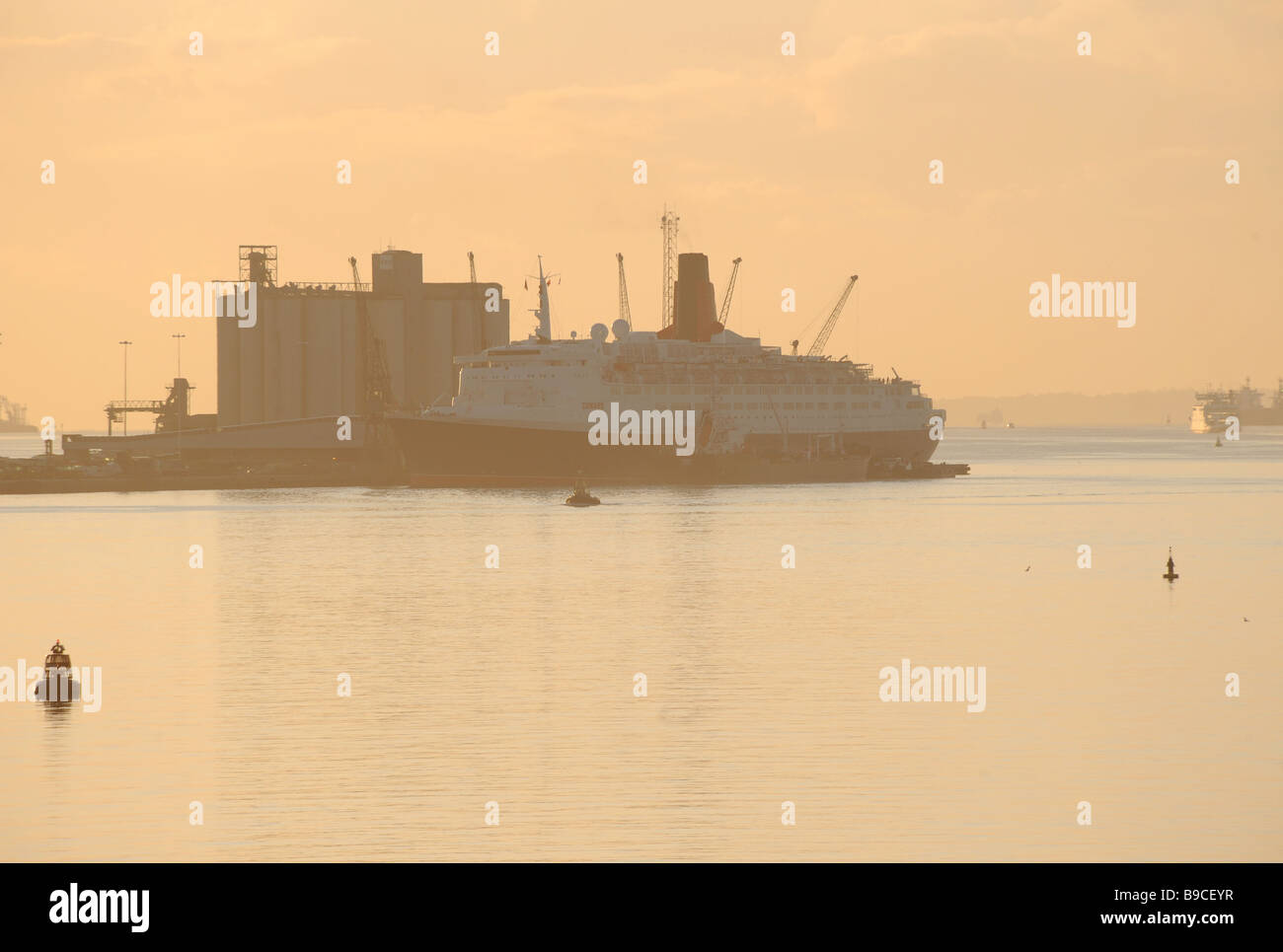 Dawn, the QE2 moored in Southampton for the last time, water shimmers ...