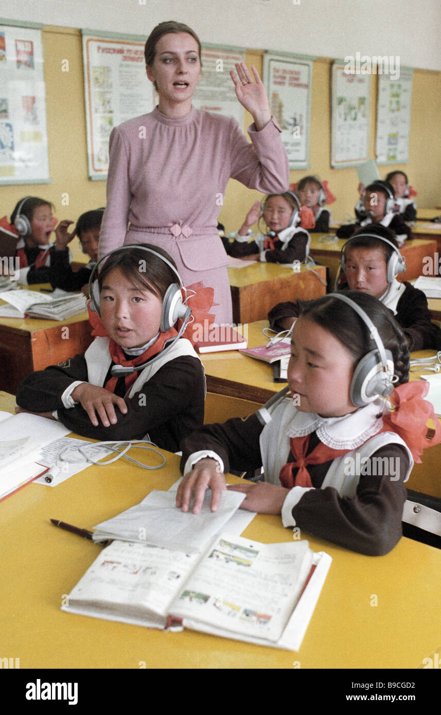 Teacher Natalia Suprun standing is conducting a lesson of Russian in a ...