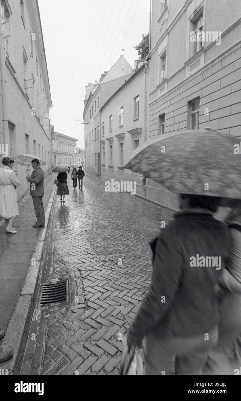 People with umbrellas walk along Gorky Street Stock Photo - Alamy