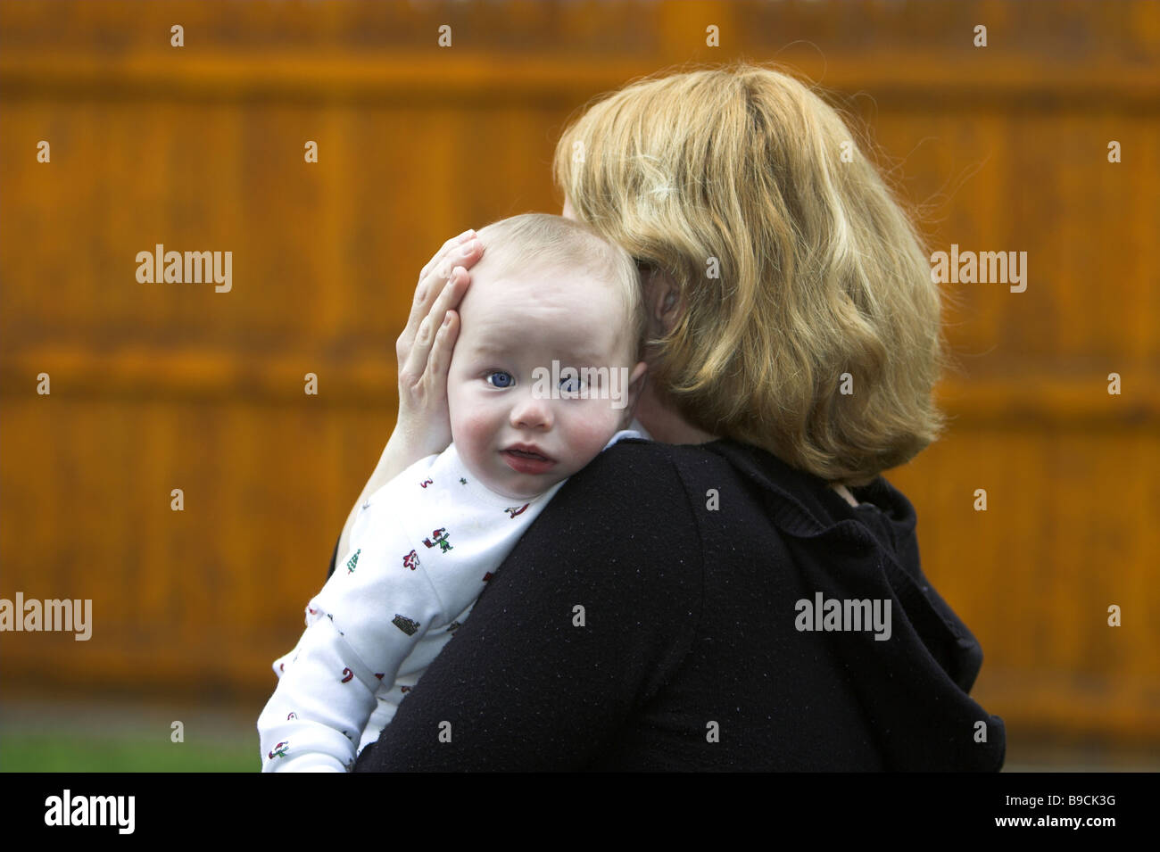 Sad blue eyed baby boy comforted by mother Stock Photo - Alamy