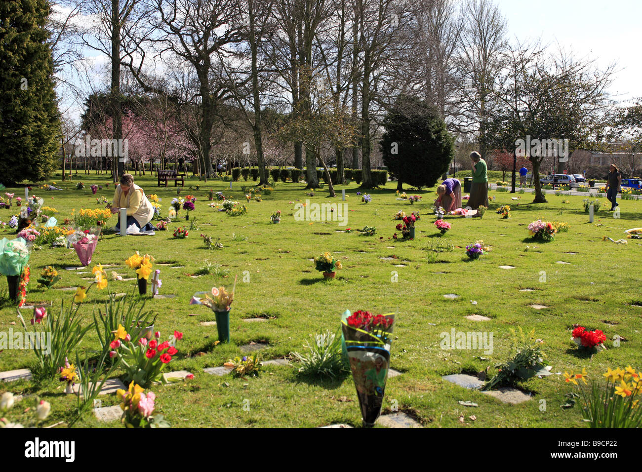 People visiting the grave of their family member with fresh flowers at ...